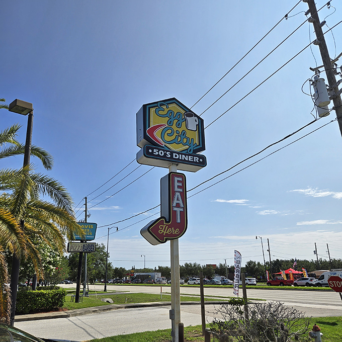 The roadside sign promises '50s diner magic and points you toward egg salvation. In Florida's morning sunshine, it's a beacon of breakfast hope.