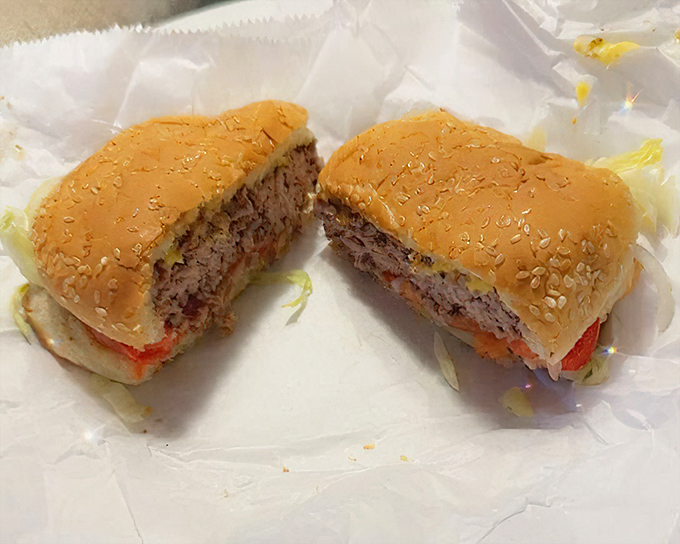 Cross-section evidence of burger perfection&mdash;juicy beef cooked just right, melted cheese, and fresh toppings on a sesame seed bun. This is burger science at its finest.