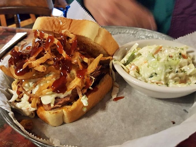 A sandwich that requires both hands, several napkins, and possibly a liability waiver. Cole slaw provides the crunch while your arteries contemplate their life choices.