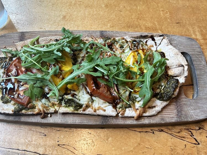 Flatbread that's having more fun than most people on vacation. Those arugula leaves dancing atop melted cheese and roasted tomatoes create pure magic.