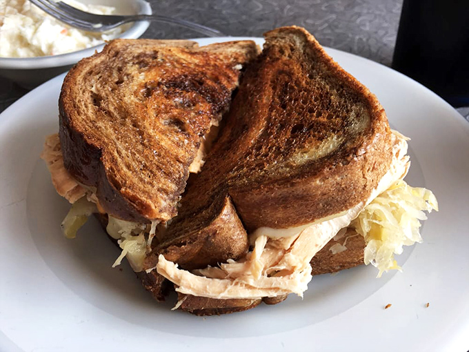 The Reuben sandwich: architectural marvel of perfectly toasted rye, turkey, kraut and cheese that requires both hands and commitment.