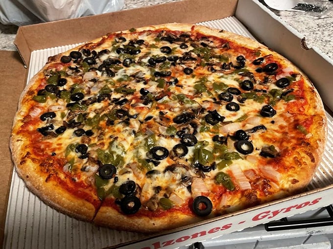 A pizza that doesn't understand the concept of "less is more." Those black olives and green peppers are having their own little garden party.