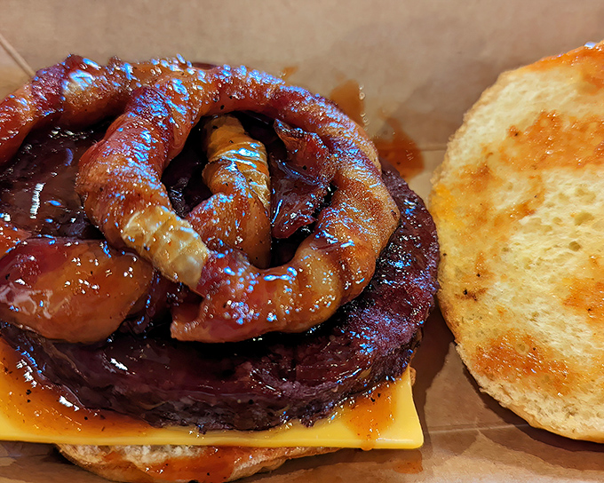 That burger is showing off with a sausage crown, because why settle for ordinary?