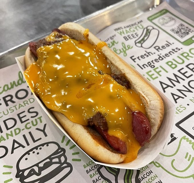 The cheese-smothered hot dog that makes you forget your table manners. When melty cheddar meets quality beef, napkins become your most essential accessory.