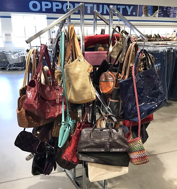 Handbags of every hue dangle like colorful fruit from a metal tree. Designer dreams and practical purses mingle in democratic fashion harmony.