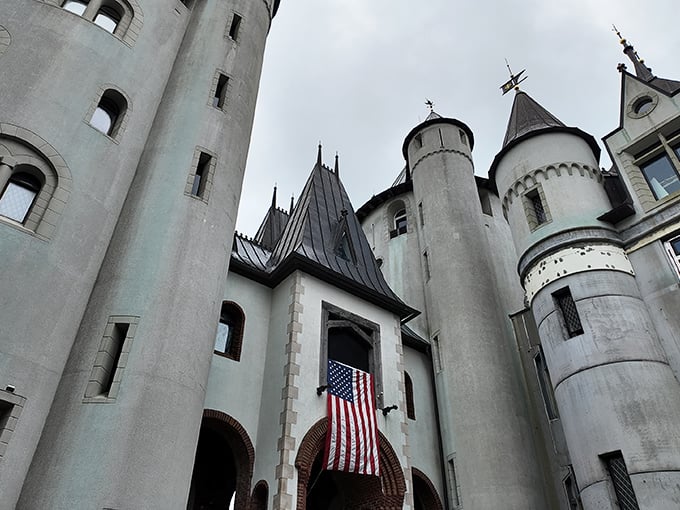 American flag meets medieval architecture in perfect harmony. Castle Gwynn's impressive towers and battlements create a striking silhouette against the Tennessee sky.