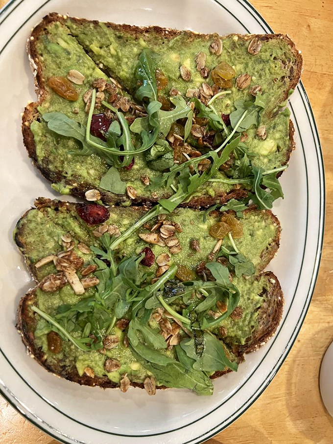 Avocado toast that's actually exciting—topped with arugula, seeds, and dried fruit, it's the breakfast equivalent of a well-accessorized outfit.
