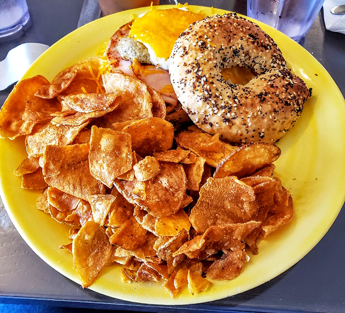The bagel sandwich that launched a thousand food dreams, surrounded by homemade chips that refuse to be upstaged.