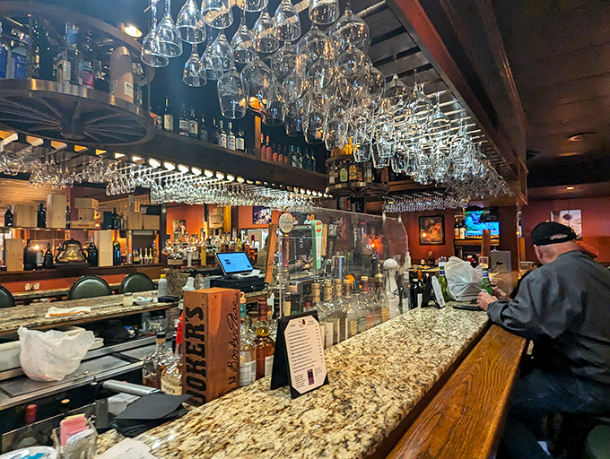 The bar area gleams with promise, where hanging glasses catch the light like liquid prisms. A cathedral dedicated to the art of hospitality.
