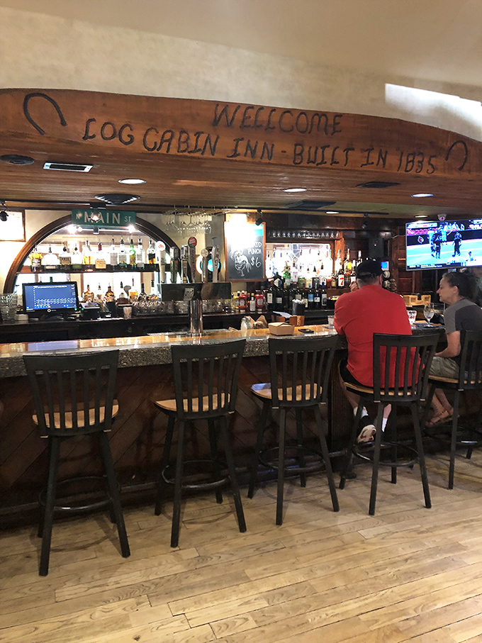 The bar at Log Cabin Inn isn't just serving drinks&mdash;it's preserving history. That wooden beam proudly announcing "Built in 1885" has stories to tell.