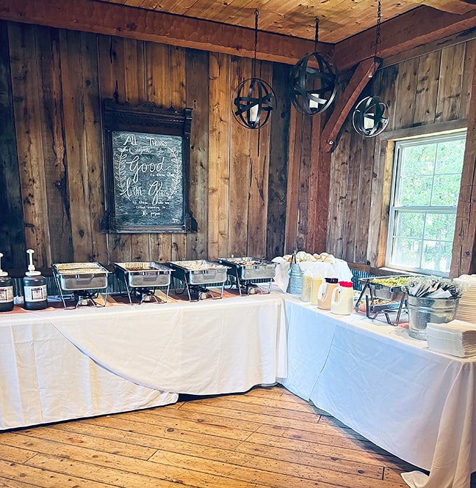 Their catering setup transforms any event into a barbecue celebration, with warming trays ready to serve crowds in what appears to be a rustic barn setting.