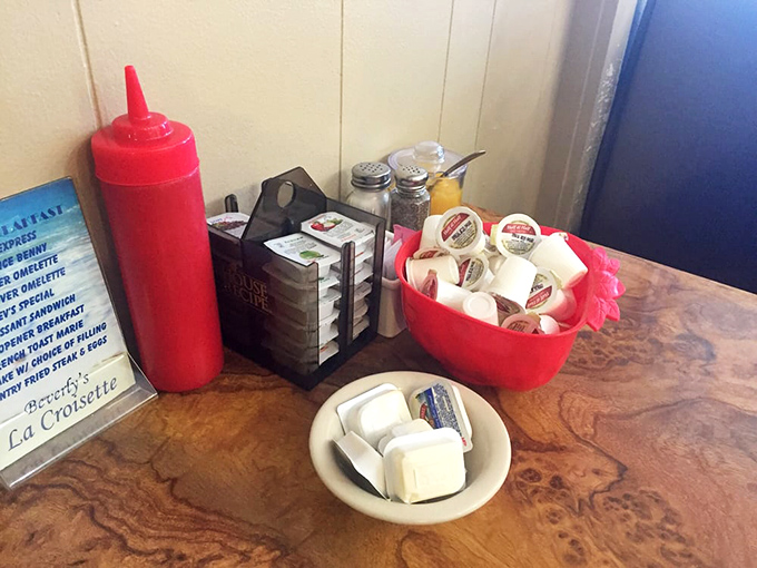 The condiment station&mdash;where ketchup meets creamer in perfect breakfast harmony. Those little butter packets are about to meet their destiny on hot toast.