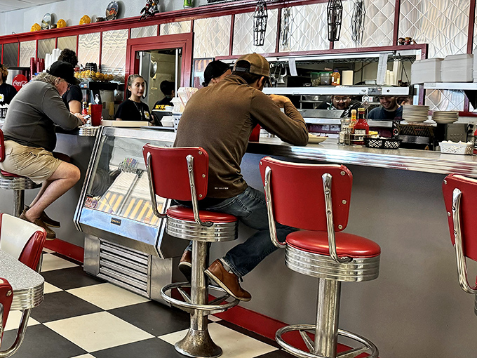 The counter seats&mdash;where solo diners become temporary family and the coffee refills flow like conversation. Breakfast theater at its finest.