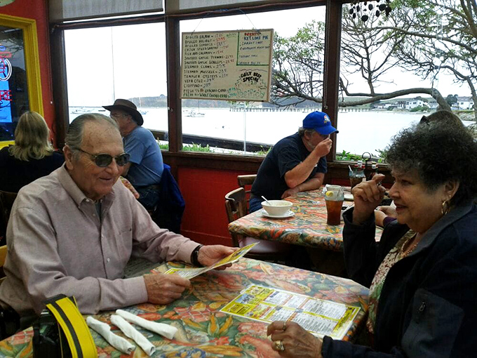Happy diners proving that the best conversations happen over plates of perfectly fried fish.