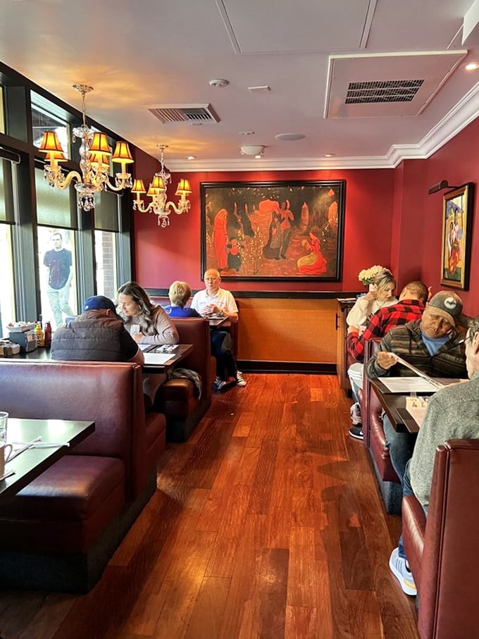The dining room hums with conversation and clinking silverware. Red walls and wooden booths create the perfect backdrop for breakfast memories.