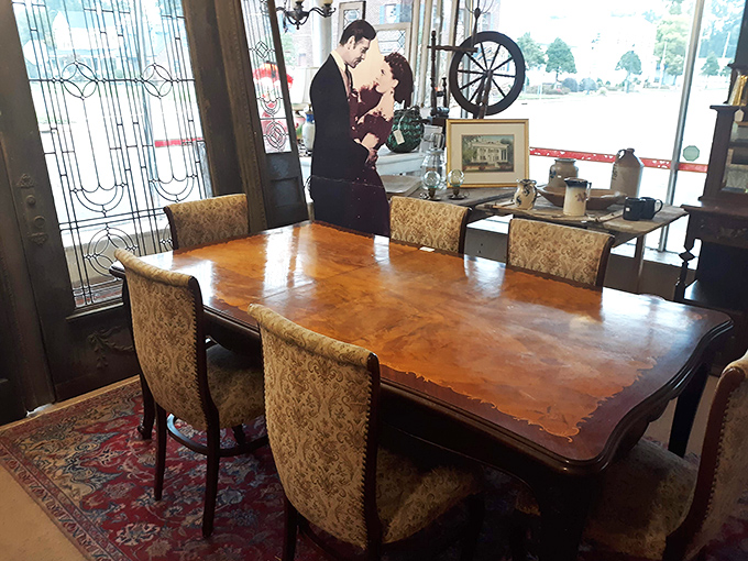 This elegant dining set waits for its next dinner party, while stained glass windows filter light that dances across the polished wood surface.