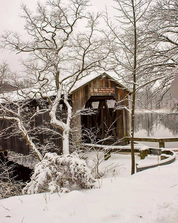 Jack Frost works his magic, turning the bridge into a winter wonderland where every snow-covered branch frames this historic wooden passage.