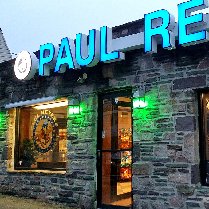 As evening falls, the green-lit entrance transforms into a beacon of hope for the hungry, promising delicious relief just steps away.