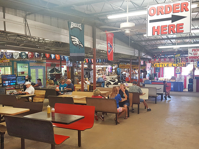 The food court: where weary shoppers refuel and compare their treasures while sports banners overhead declare team loyalties louder than words.