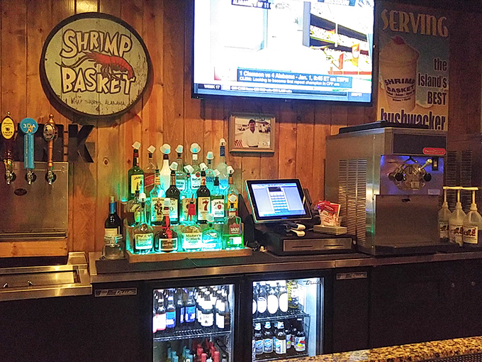 Behind the bar, bottles glow like an aquatic light show, with the Shrimp Basket logo proudly announcing you've found your seafood sanctuary.