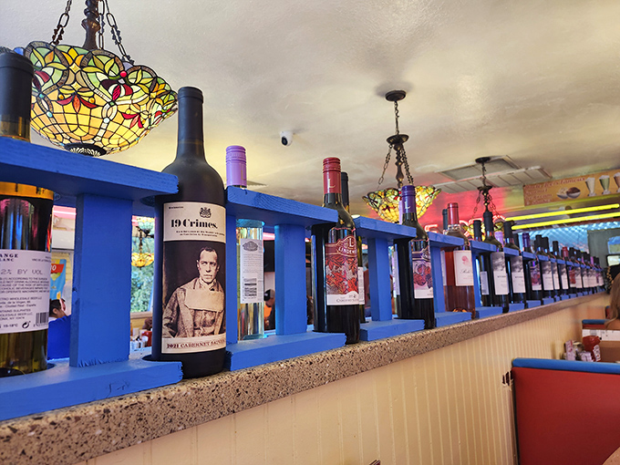 Wine bottles line blue shelves like sentinels guarding the secret to a good meal&mdash;proof that this diner understands food is meant to be celebrated.