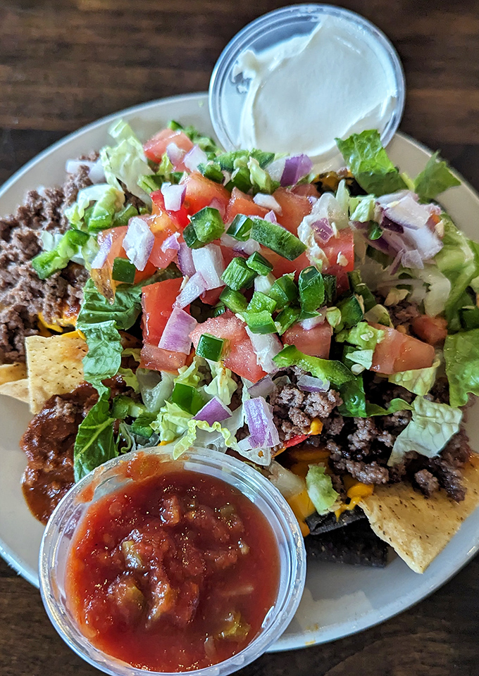 Loaded nachos arrive like a colorful celebration on a plate, topped with fresh ingredients that make sharing almost impossible.