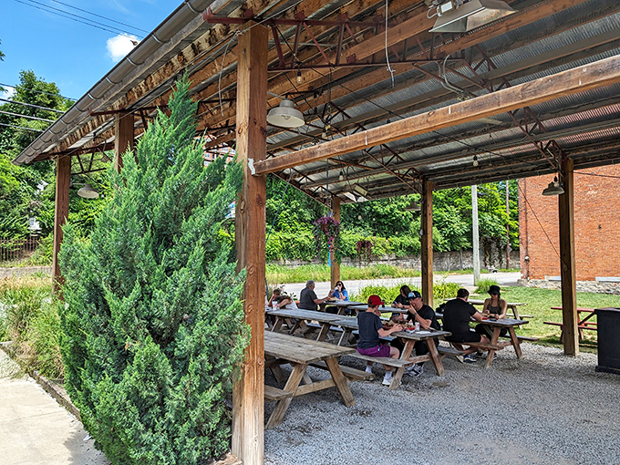 Al fresco dining under a rustic pavilion where picnic tables become community gathering spots for the universal language of "mmm" and "wow."