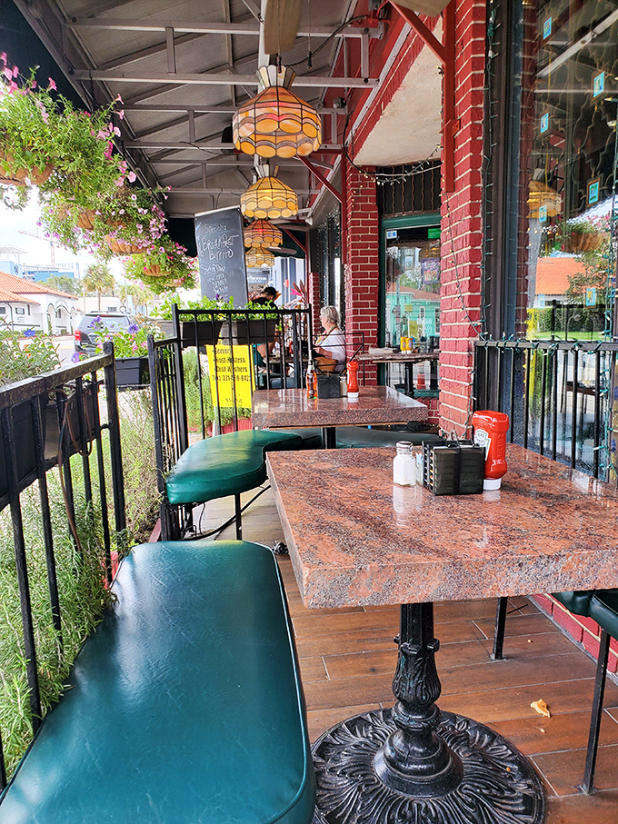 The outdoor seating area offers a front-row view of Ivanhoe Village life, with hanging lamps casting a warm glow as Orlando buzzes by.