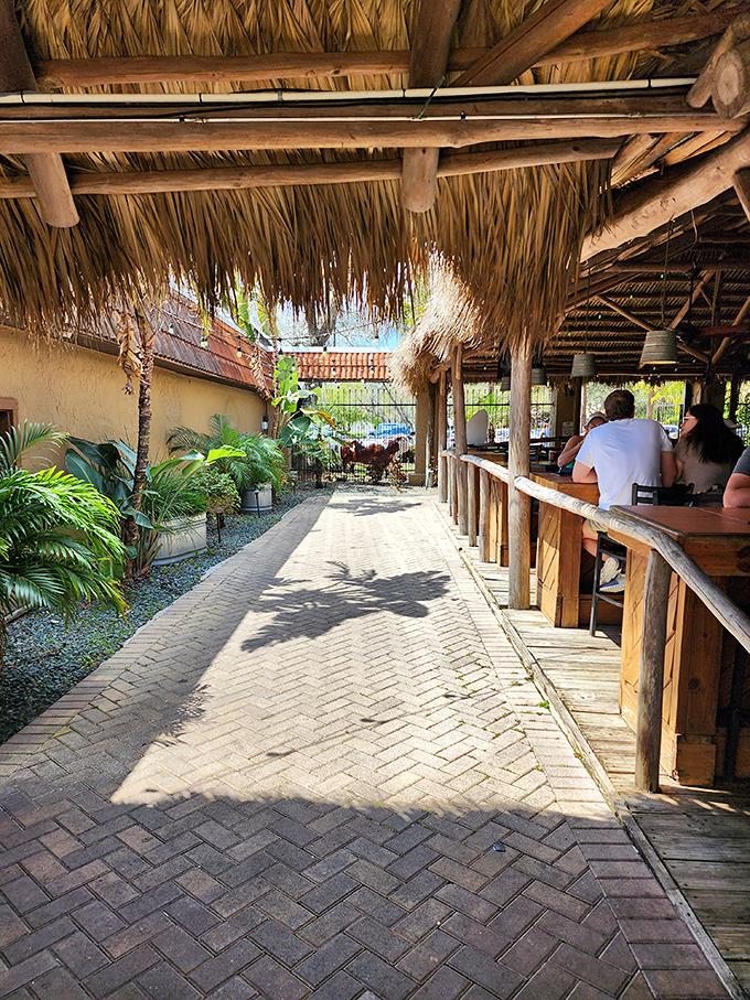 Florida's version of al fresco dining comes with palm fronds and thatched roofs. This breezy walkway leads to outdoor seating that feels like a tropical getaway.