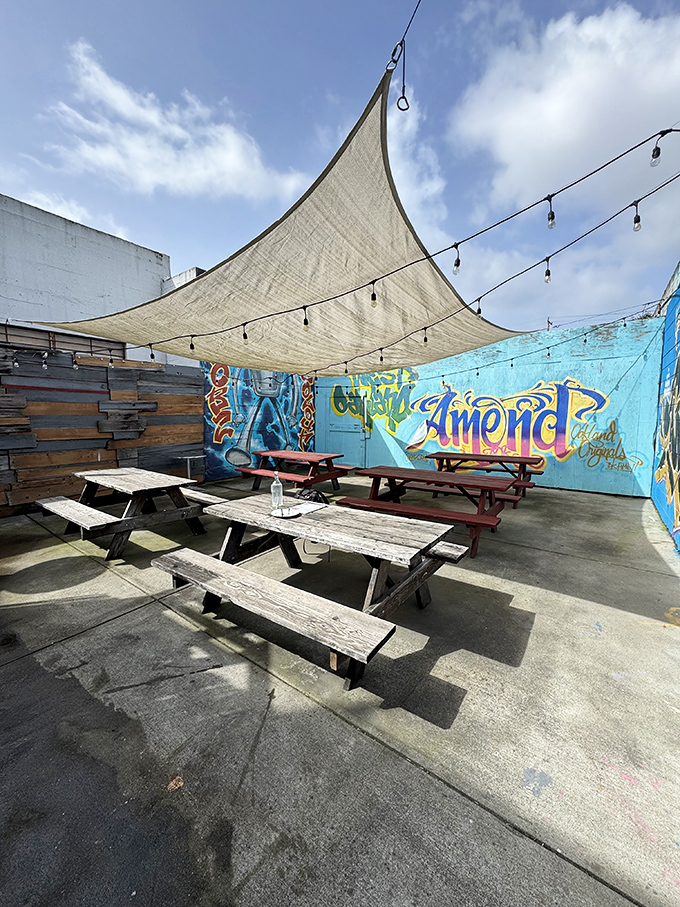 The patio at Spinning Dough offers urban sanctuary vibes with picnic tables, string lights, and colorful murals&mdash;a perfect California pizza paradise.