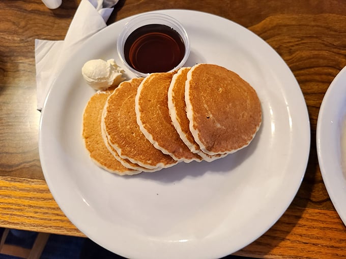Pancakes stacked like golden discs of happiness, waiting for their maple syrup baptism. Breakfast doesn't get more classically comforting than this.