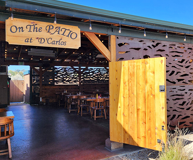 "On The Patio at D'Carlos" &ndash; where fresh air enhances every bite. Wooden accents and artistic screens create an outdoor room worth lingering in.