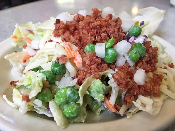 This isn't just coleslaw&mdash;it's a carnival of textures and flavors with peas, bacon bits, and a creamy dressing that makes vegetables worth celebrating.