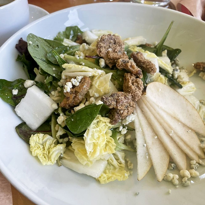 A symphony of textures – crisp greens, candied nuts, and sliced pears create a salad that makes you forget you're being healthy.