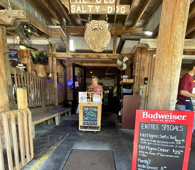 The entrance sets the tone: rustic wood, a carved dog mascot, and daily specials that make decision-making the hardest part of your visit.