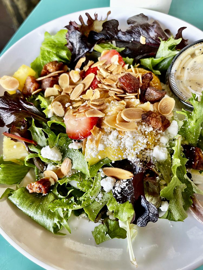 A salad that doesn't apologize for being a salad. Those toasted almonds and fresh fruit are saying "you won't miss the fried stuff."