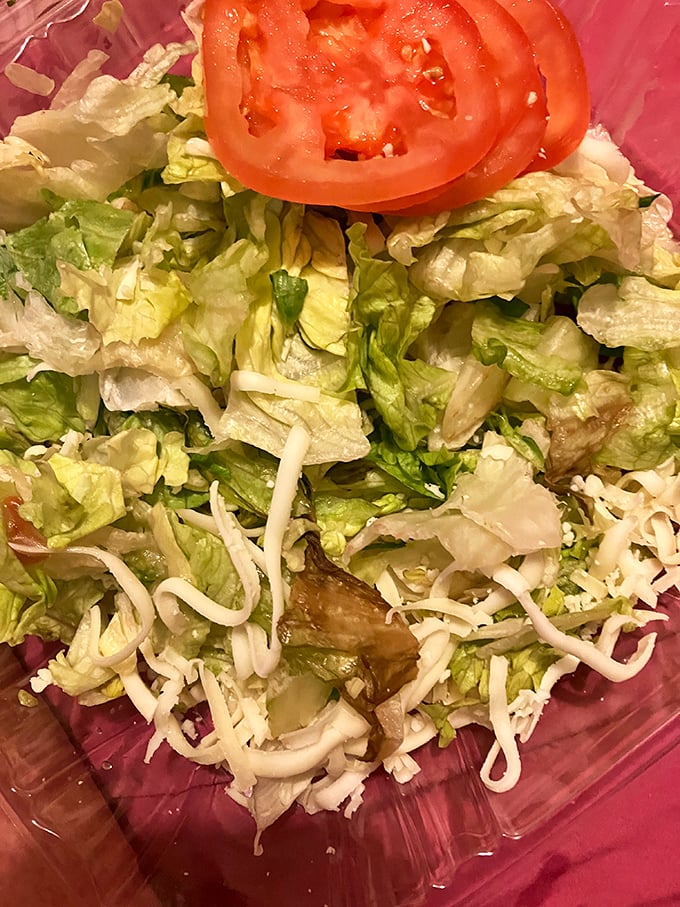 Fresh lettuce, crisp vegetables, and the promise of balance. Because sometimes you need a salad to justify that second slice of pizza.