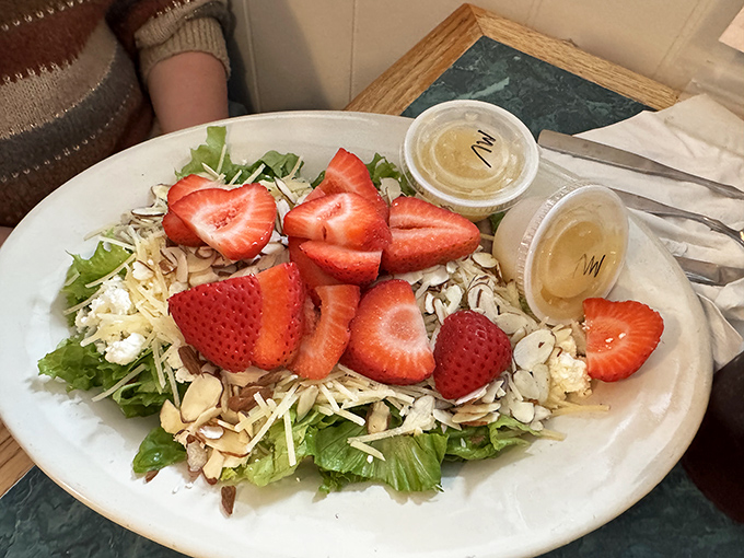 A salad that defies the "rabbit food" stereotype—fresh strawberries and crunchy almonds proving healthy eating doesn't have to be punishment.