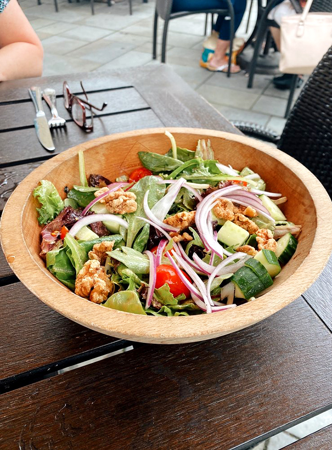 A wooden bowl cradles a salad so fresh and colorful it could double as a centerpiece. Those red onions add just the right amount of attitude.