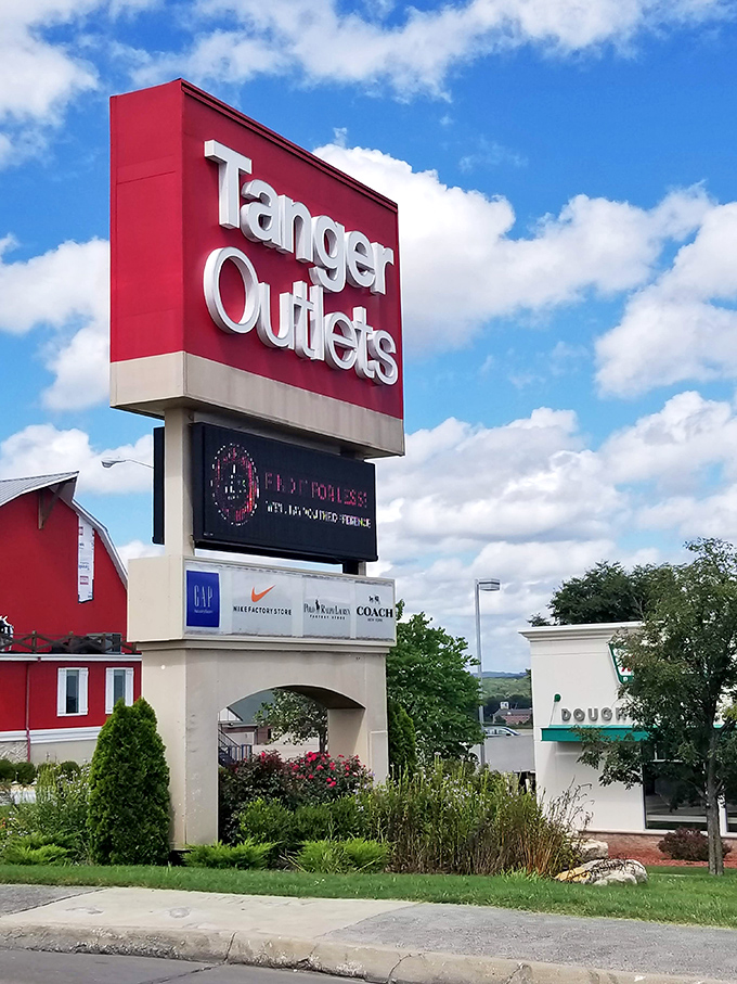 Tanger's towering sign stands as a beacon to bargain hunters. The digital display below keeps shoppers informed of the latest deals and events.