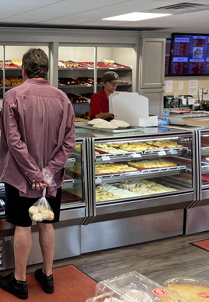 The sacred transaction &ndash; a customer clutches his bag of donuts like precious cargo while the staff prepares to make another food dream come true.