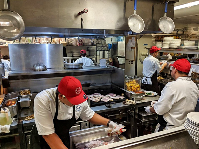 Behind every perfect seafood dish is a kitchen crew in red caps, orchestrating culinary magic with the precision of symphony conductors.