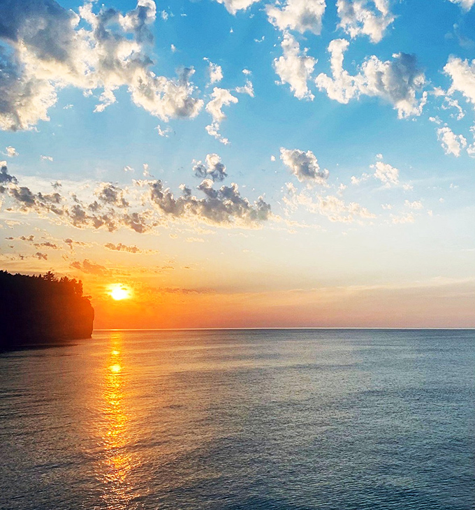 Sunset ignites the horizon where cliff meets sky, turning Lake Superior into a mirror of liquid gold that no filter could possibly improve.