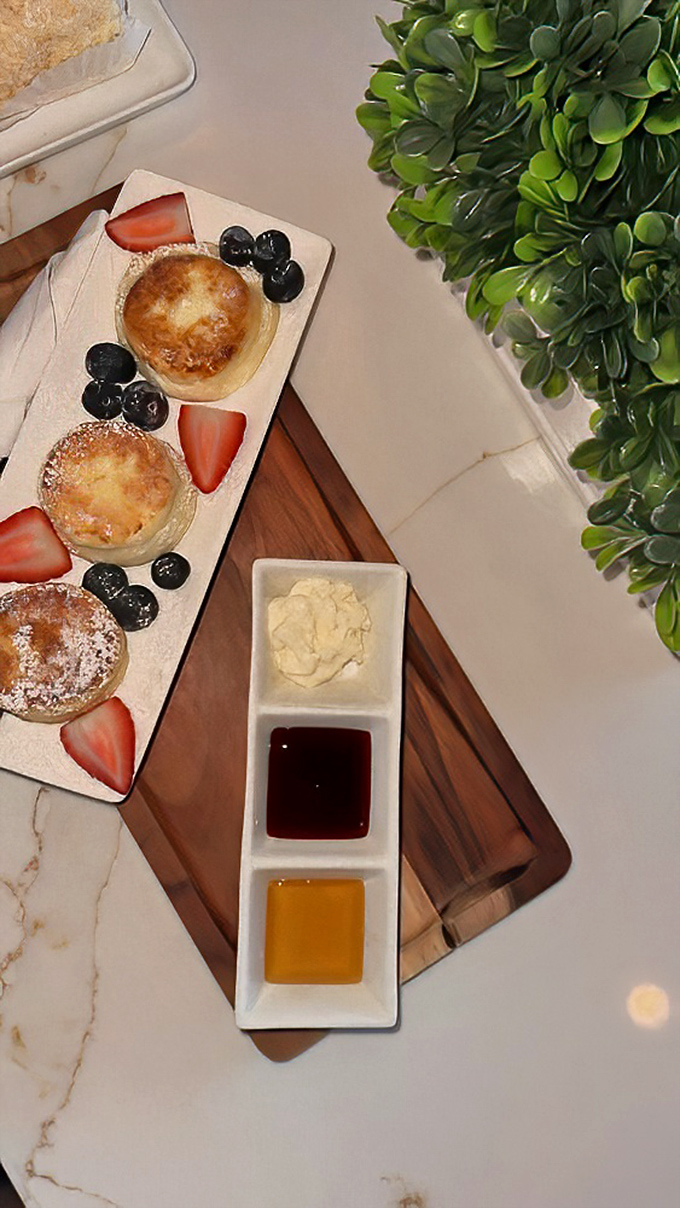Syrniki that deserve their own fan club. These cheese pancakes with fresh berries and dipping sauces make breakfast feel like an event worth dressing up for.