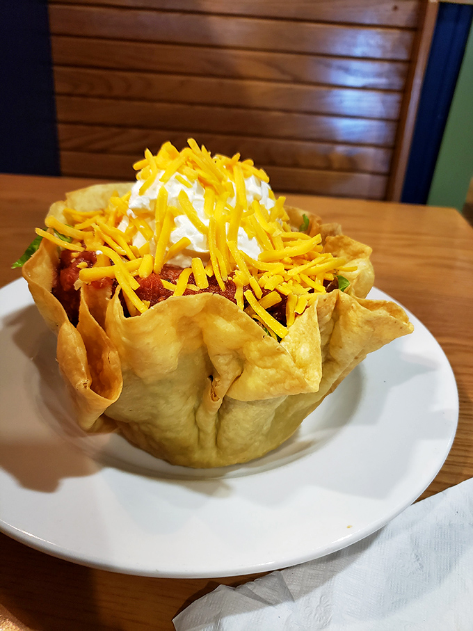 Taco salad served in a freshly fried tortilla bowl&mdash;a crunchy, edible vessel holding a fiesta of flavors topped with a snow-capped mountain of sour cream.