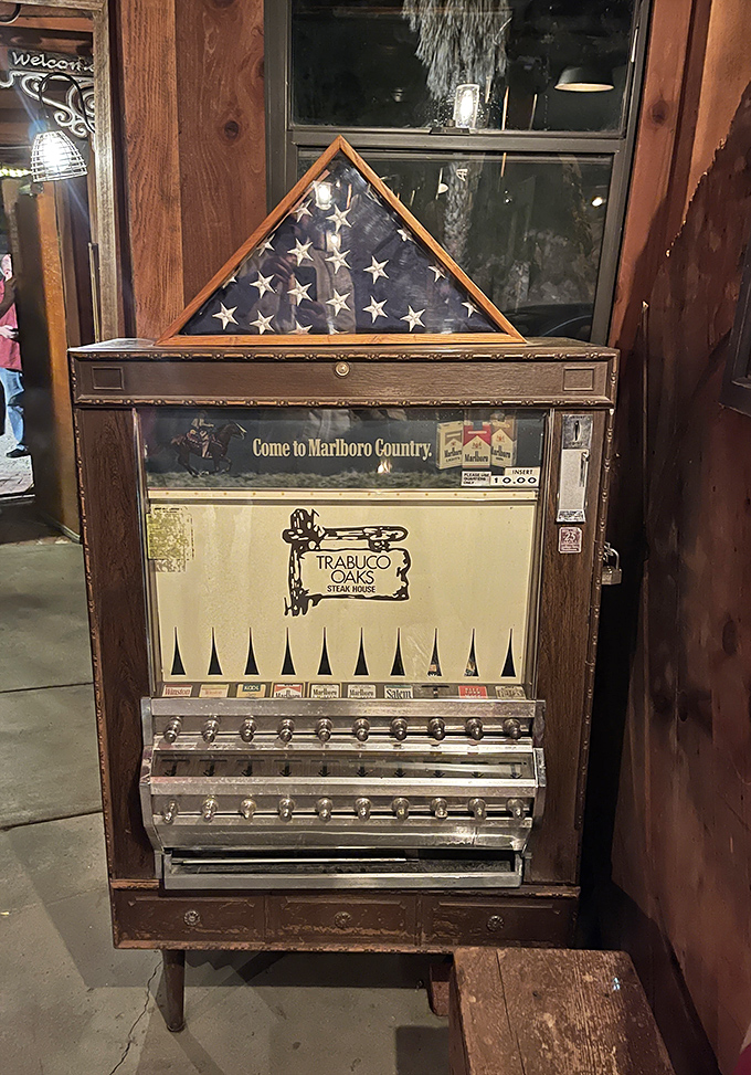 A vintage cigarette machine stands as a museum piece from another era, when dinner and smoking went together like steak and potatoes.