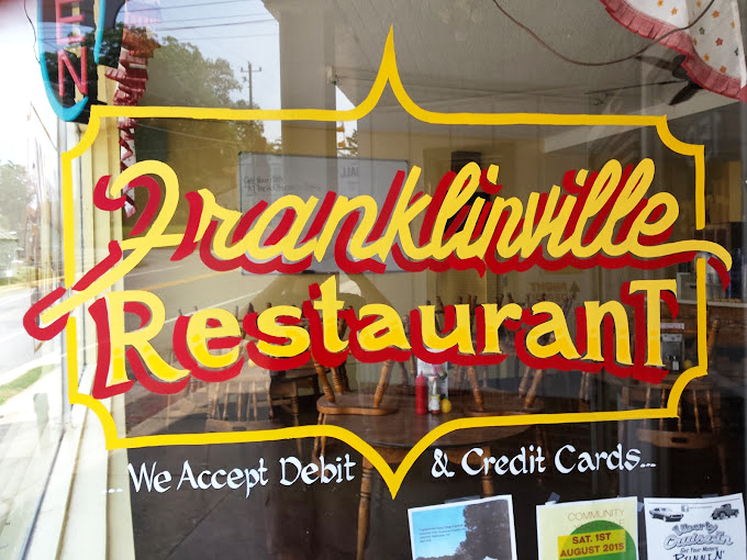 The promise of good food and modern convenience – vintage lettering with a practical postscript about payment options that bridges past and present.