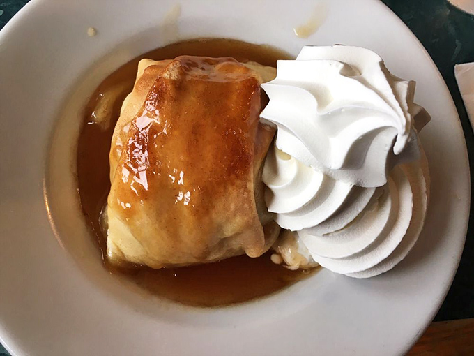 The legendary apple dumpling in all its glory. That pastry hasn't just been baked&mdash;it's been loved, and that whipped cream crown is well-deserved royalty.