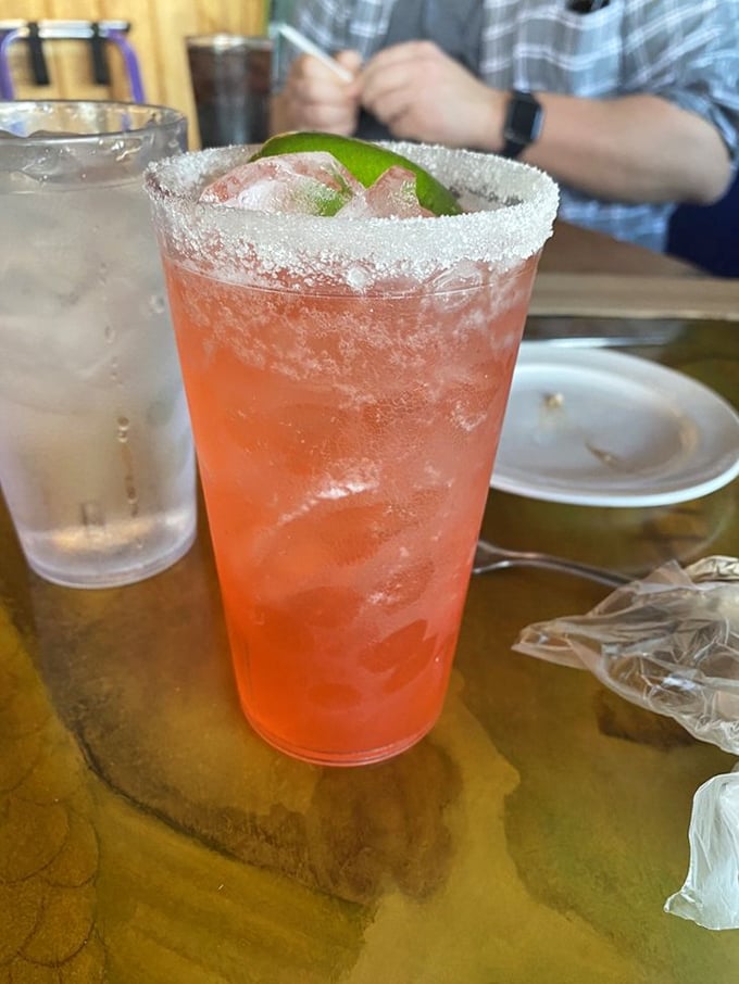 A Bahama Mama cocktail with its sugar-rimmed glass and lime wedge—because seafood deserves a tropical companion with attitude.