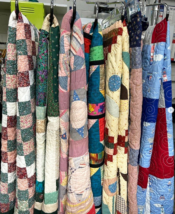 Handmade quilts hang like textile art galleries. Each stitch represents hours of craftsmanship, ready to bring both warmth and character to your bedroom.